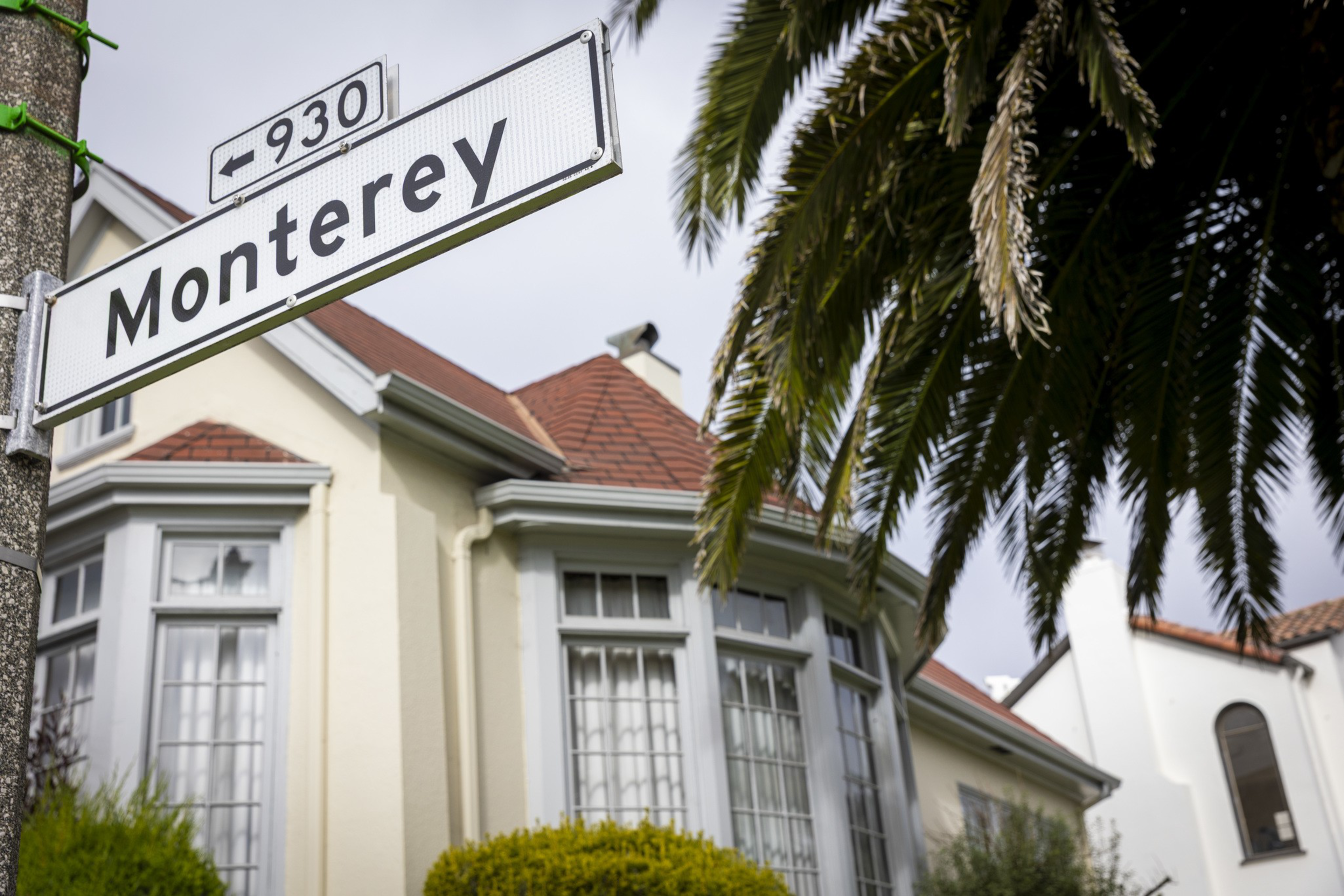 A street sign labeled "Monterey" with the number 930 points left, set ...
