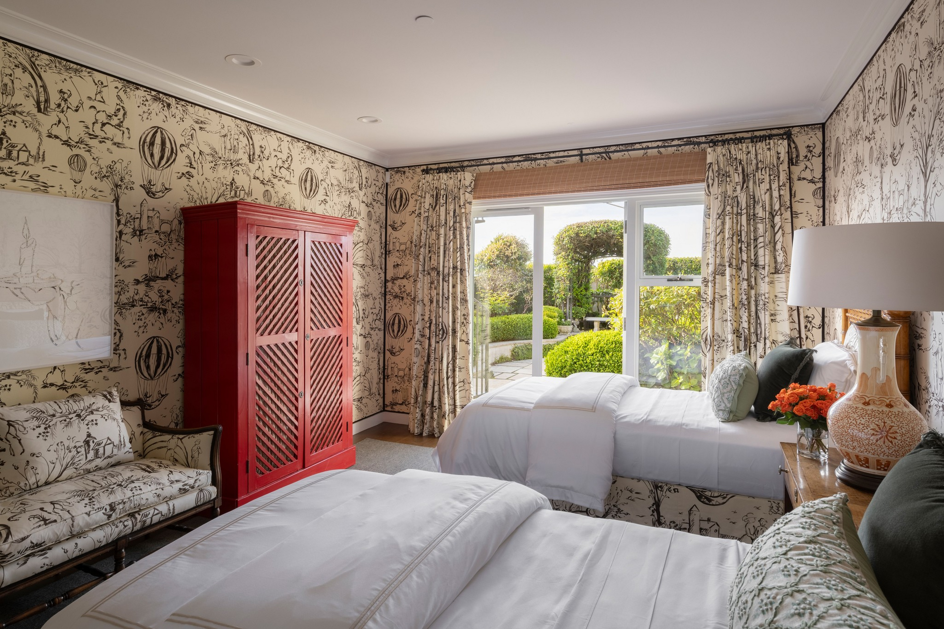 Two twin beds with white bedding face a large window overlooking a ...