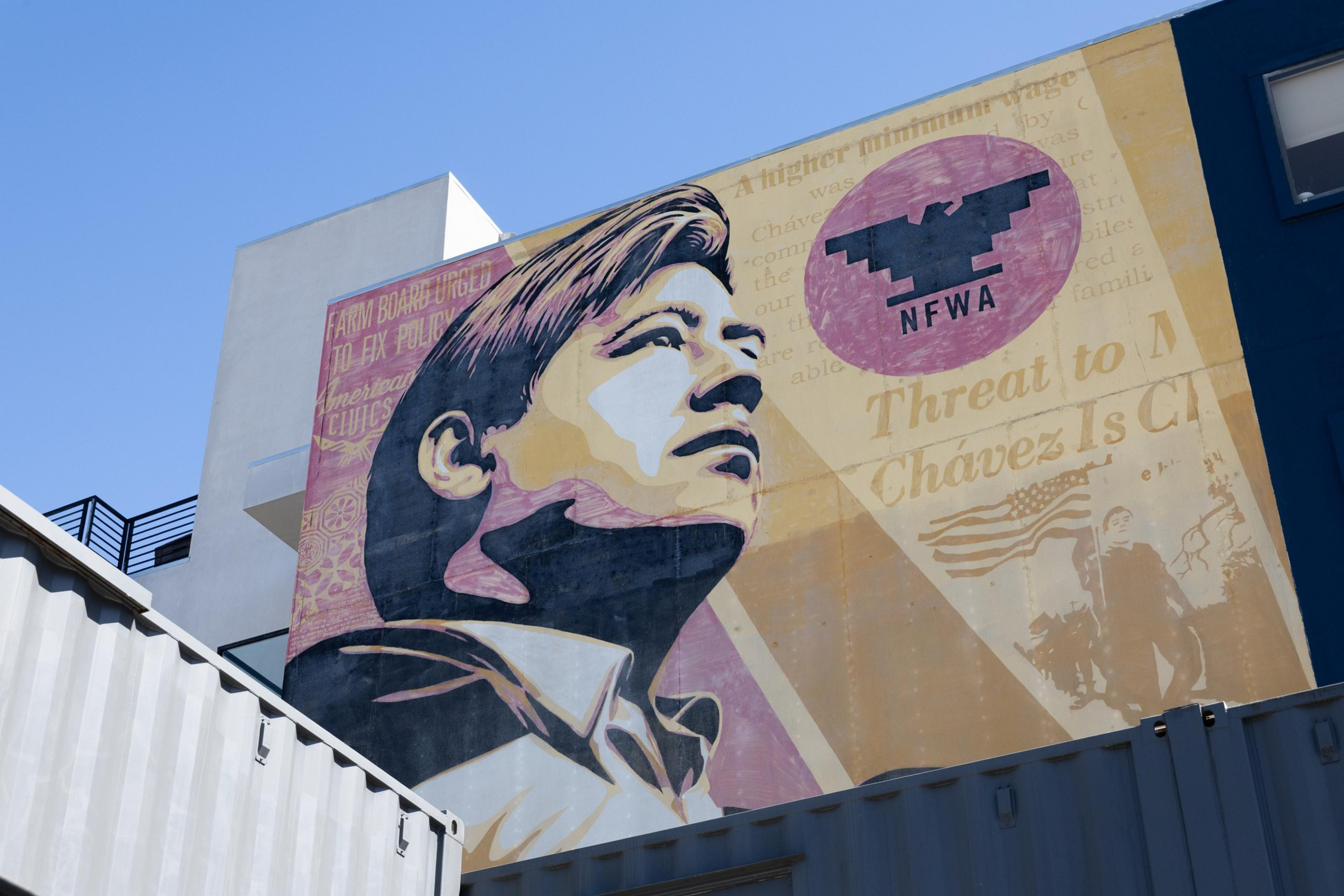 A large mural of a young man looking upward with the NFW logo and faded ...