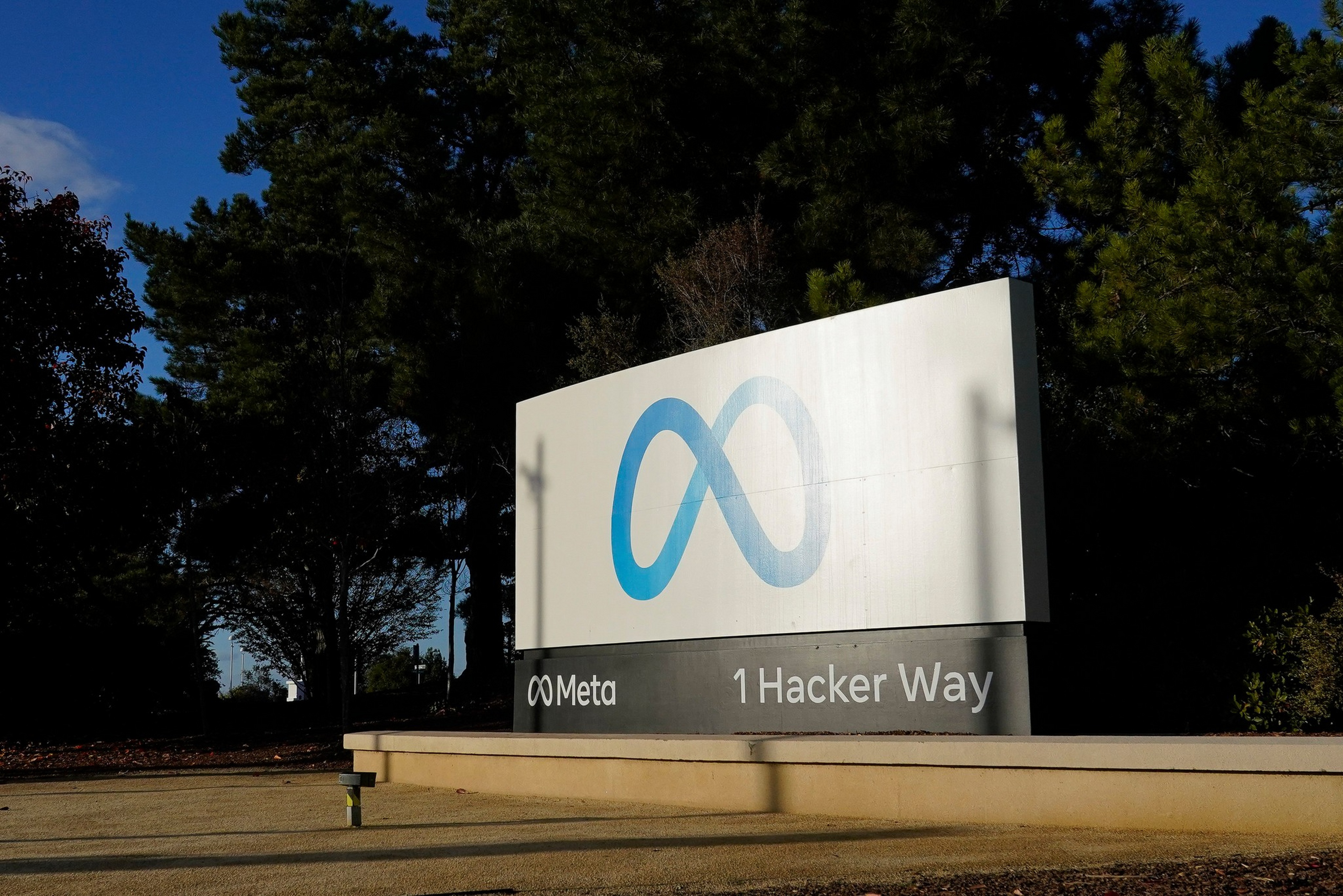 A large white sign with a blue infinity loop logo, "Meta" name, and "1 ...
