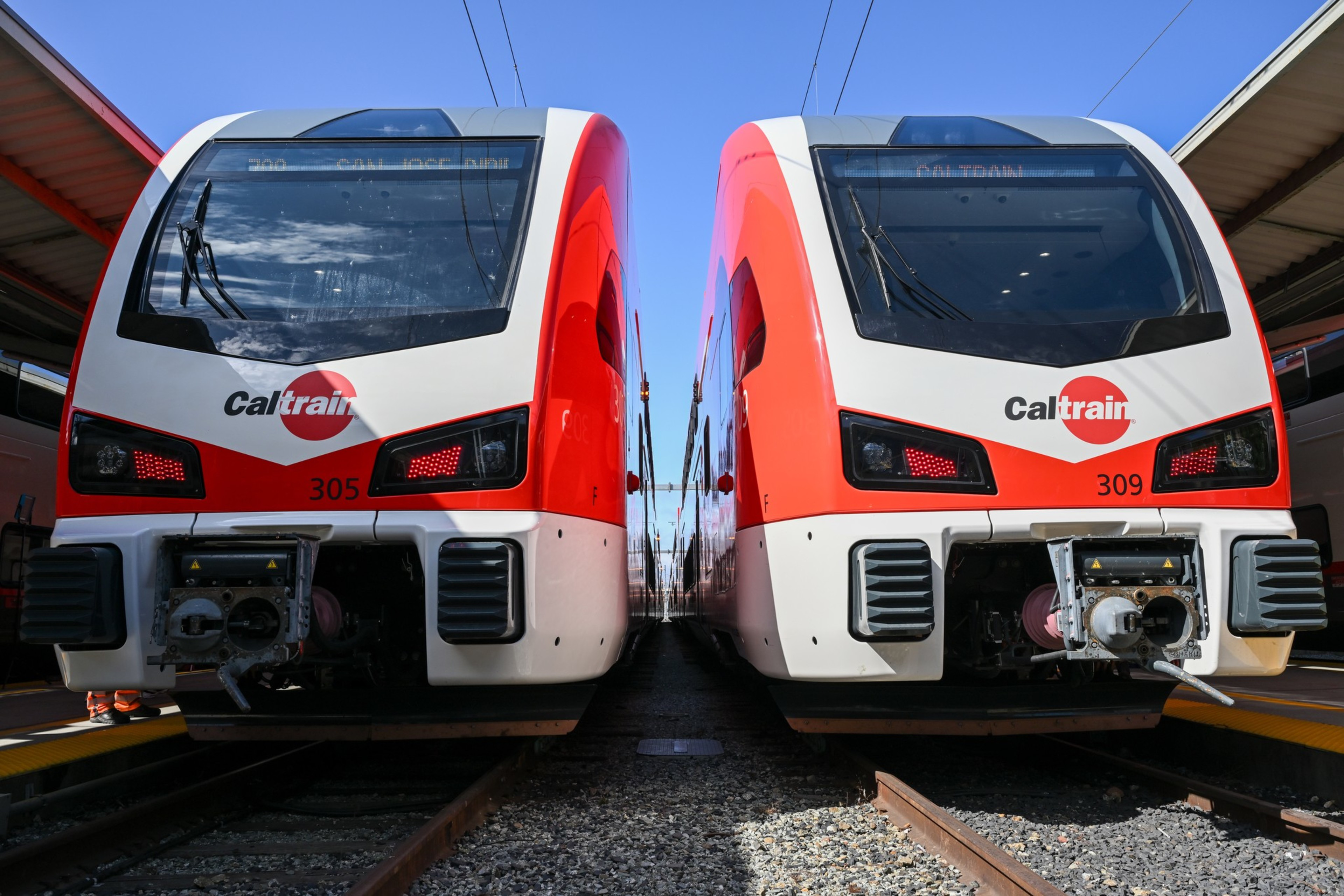 Two modern Caltrain locomotives, numbered 305 and 309, are parked side ...