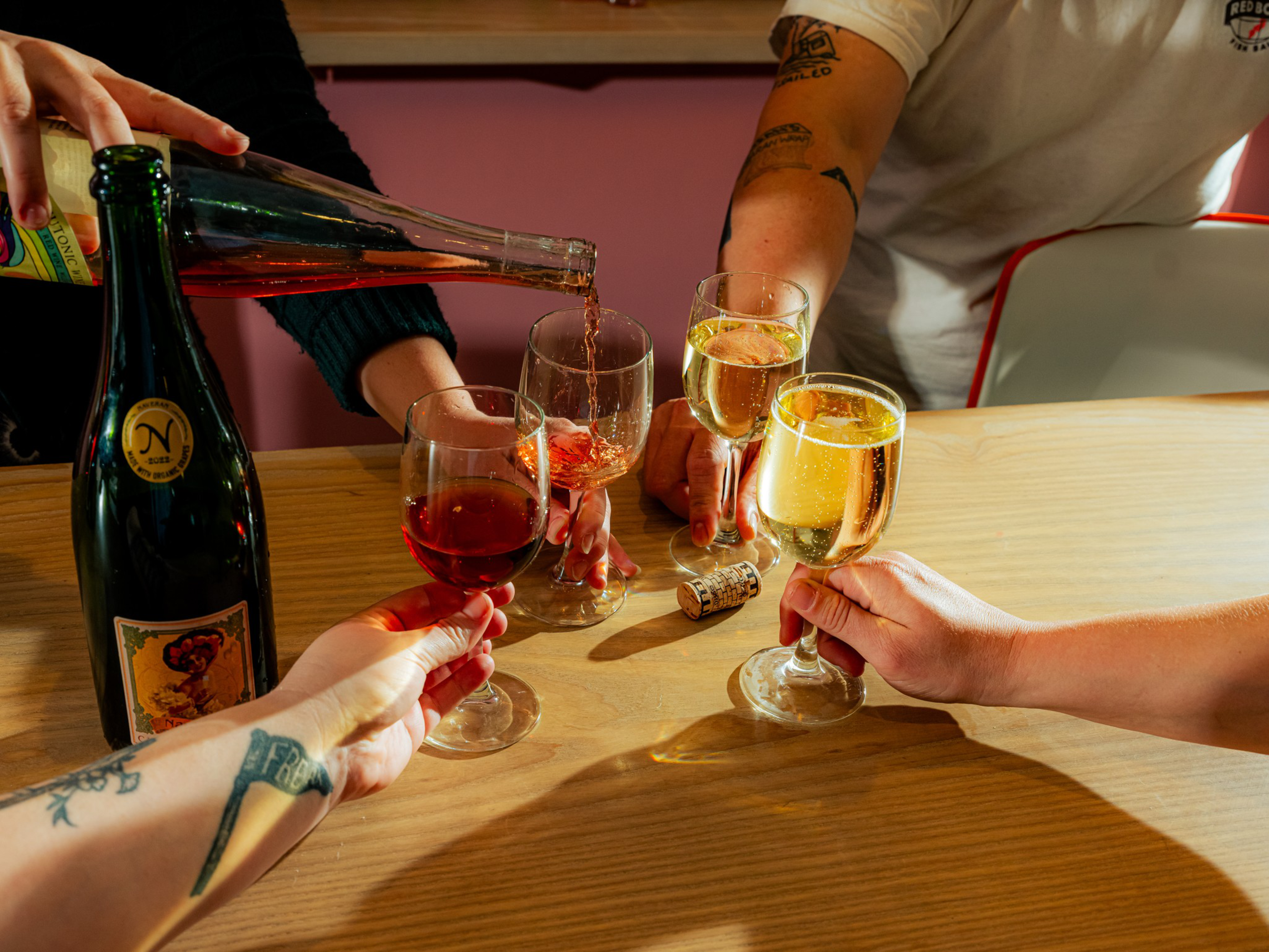 Four people are holding glasses filled with red and white sparkling ...