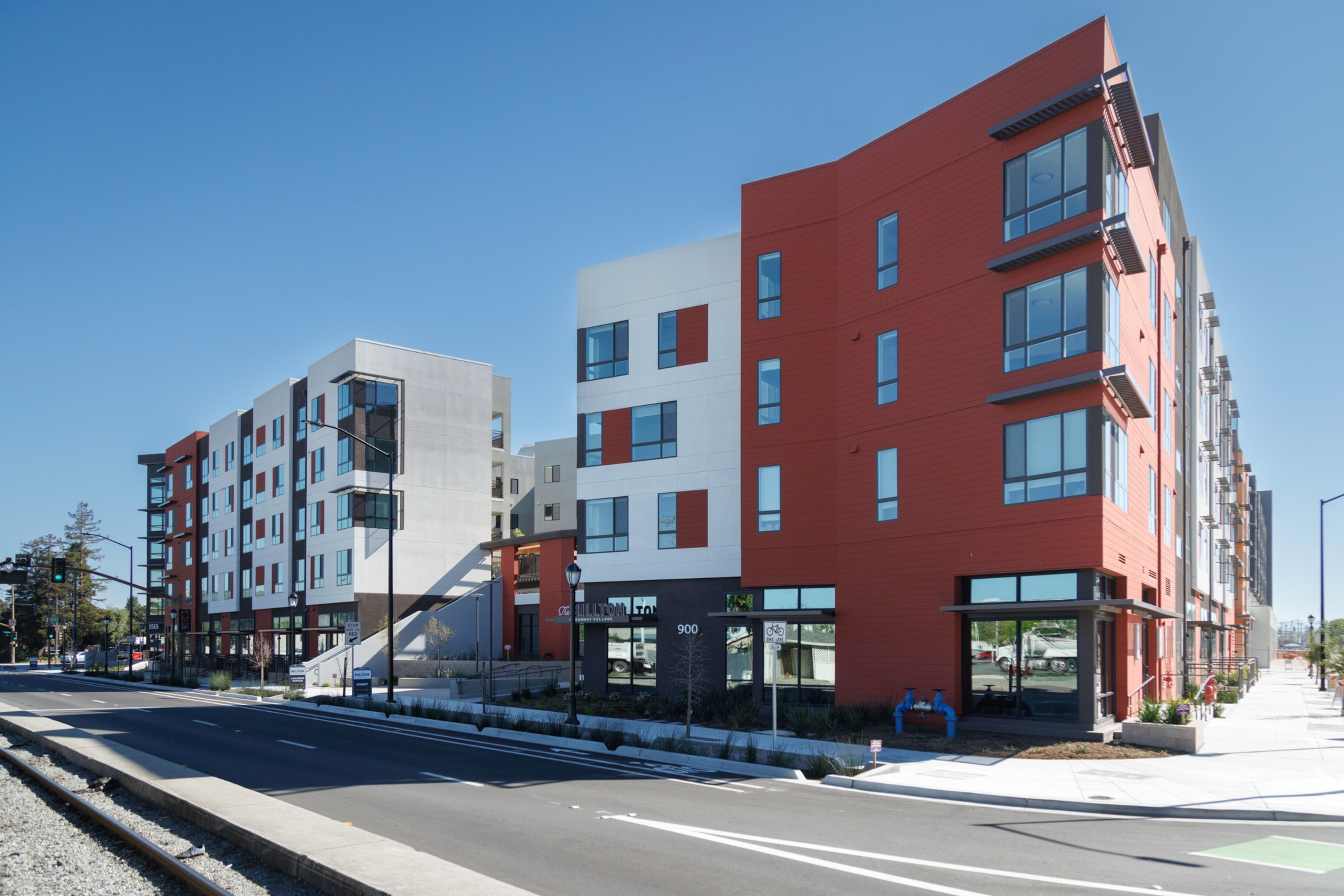 A modern, multi-story apartment building with red and white exterior ...